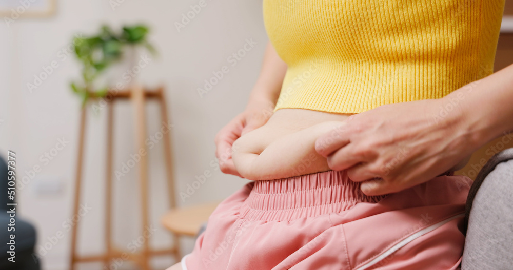hand pinch excessive belly fat Stock Photo | Adobe Stock