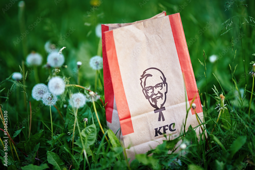 Minsk, Belarus. Jun 2022. KFC Paper bag on green grass and dandelions ...