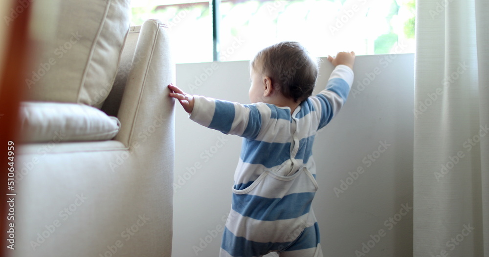 Cute baby boy standing up at home. Infant child learning development ...