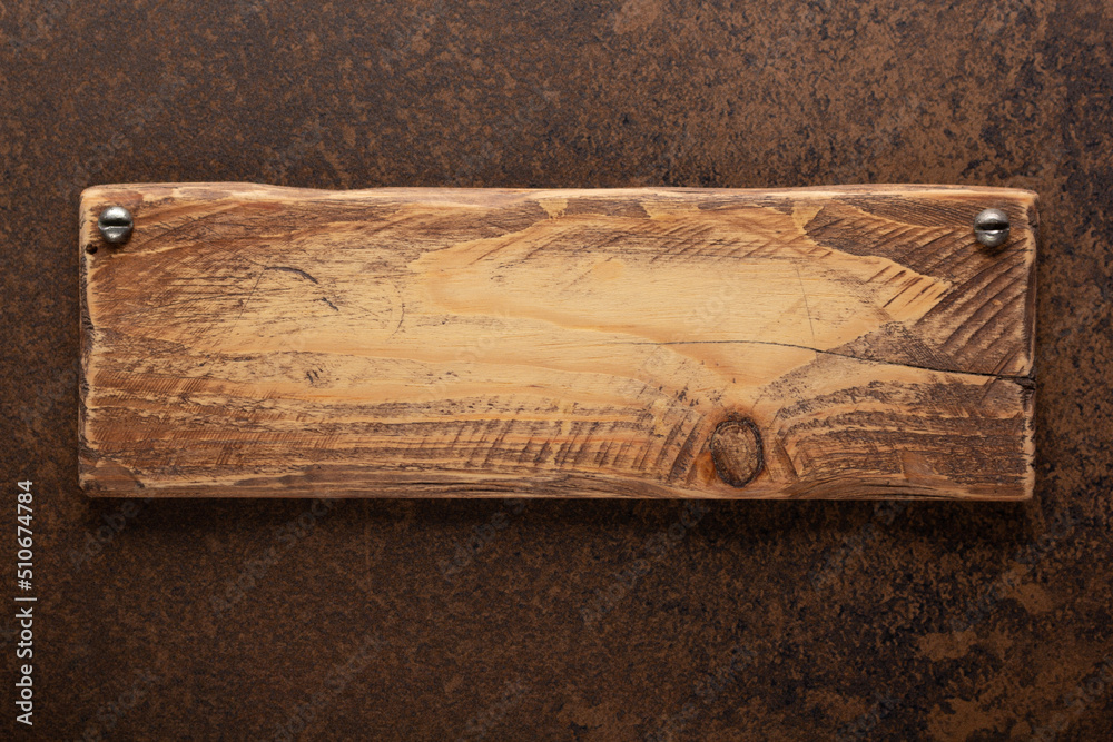 Wooden nameplate or sign board screwed at wall background. Front view ...