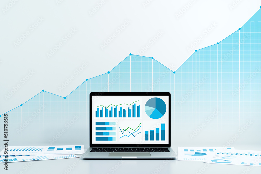 Analyzing business data and growth. Laptop and reports. Blue graphs and ...