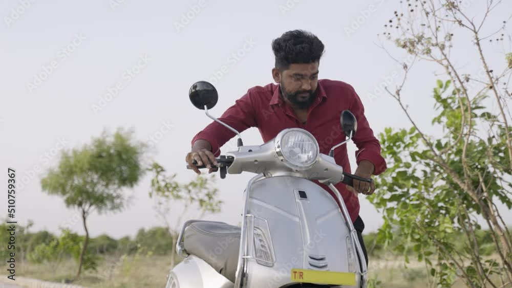 tired young man pushing Ev or electric scooter on road druring travel ...