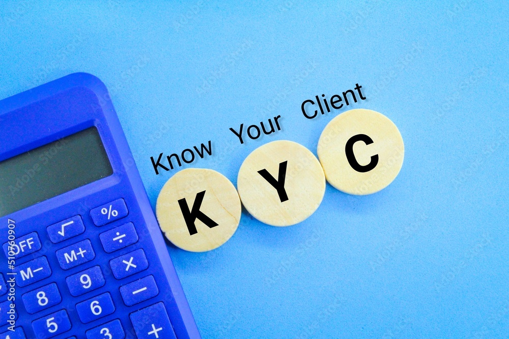 calculator and wooden circle with the words know your client or the ...
