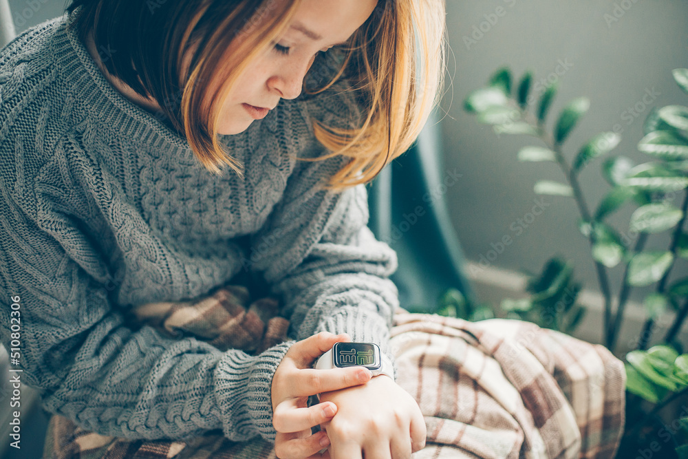 Pre-teen girl using touchscreen smart watch. Modern technology concept ...