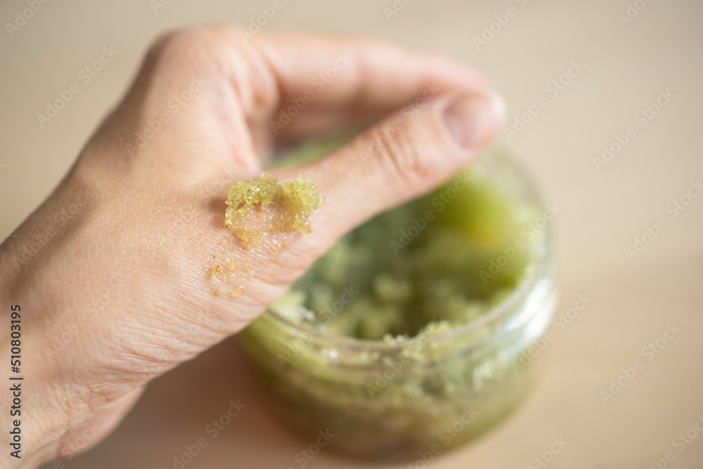 testing scrub green, on the skin of the hand. Jar with green scrub ...