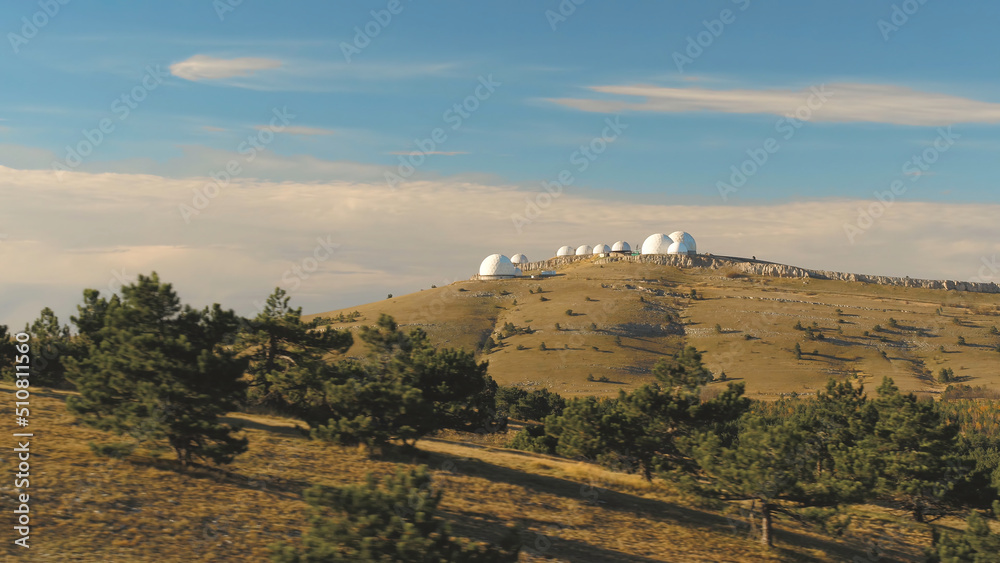 Top view of white domed buildings of observatories on hill. Shot ...
