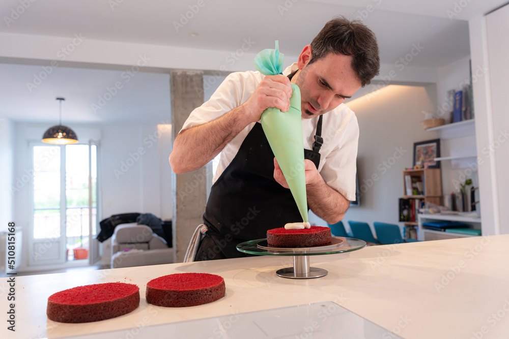 A challenger man cooking a red velvet cake at home, assembling the ...
