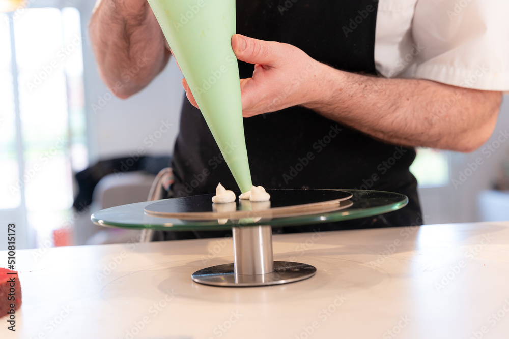 Hands of a man cooking a red velvet cake at home, assembling the triple ...