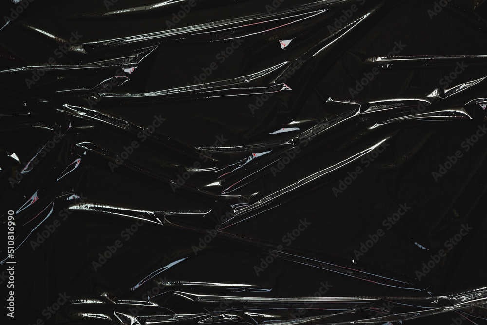 Crumpled wrinkled plastic cellophane. Transparent plastic wrap on black ...