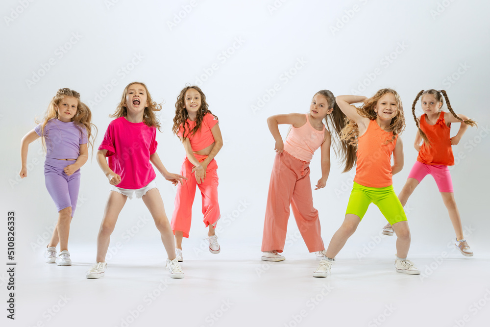 Dance group of happy, active little girls in bright colorful clothes ...