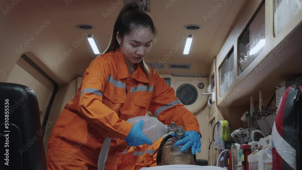 Female emergency medical team helps a sick person in an ambulance with ...
