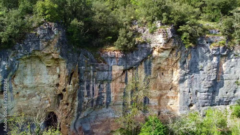 Falaise calcaire ensevelie par la végétation et éclairée par le soleil ...