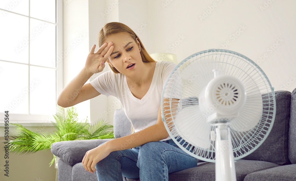 Woman tired of sweltering summertime heat. Young girl sitting in ...