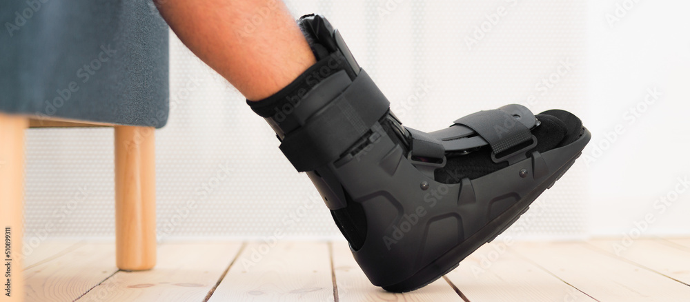 Ankle sprain orthosis, black splint, walker boot on leg sitting on the ...