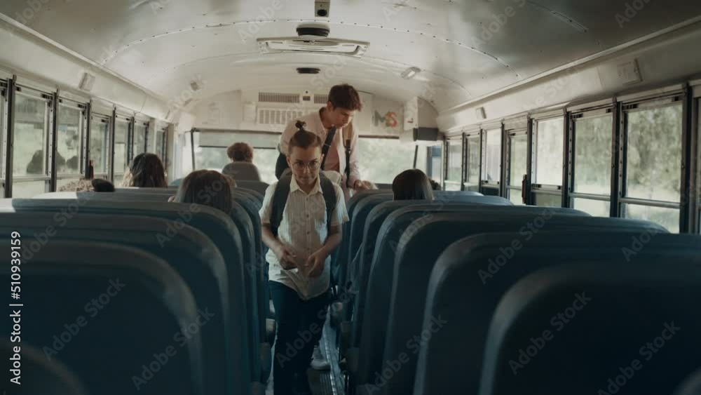 School children taking seats in school bus. Teenage pupils boarding on ...