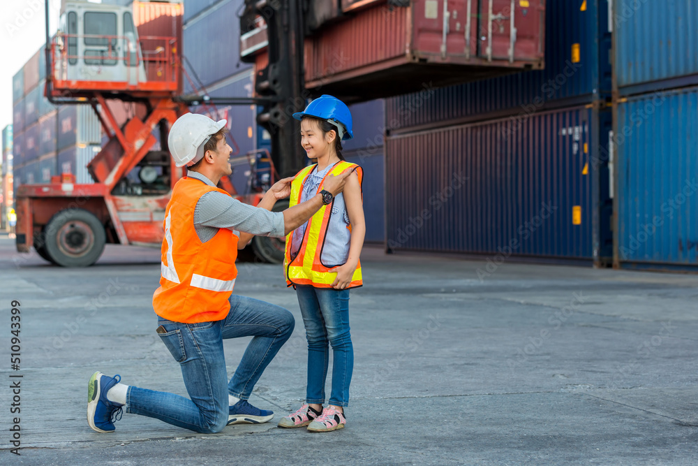Father and little daughter wearing a safety helmet at Container cargo ...