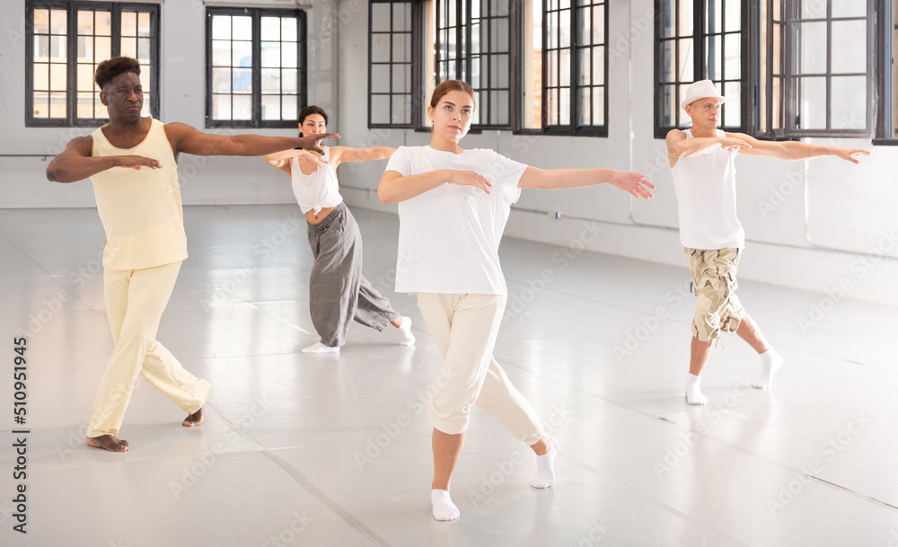Four dancers exercising modern dance movements in large ball room Stock ...