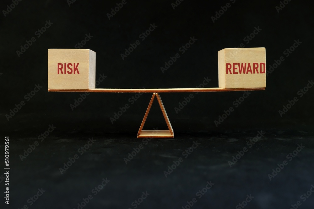 Balancing risk and reward word on seesaw scale in dark black background ...