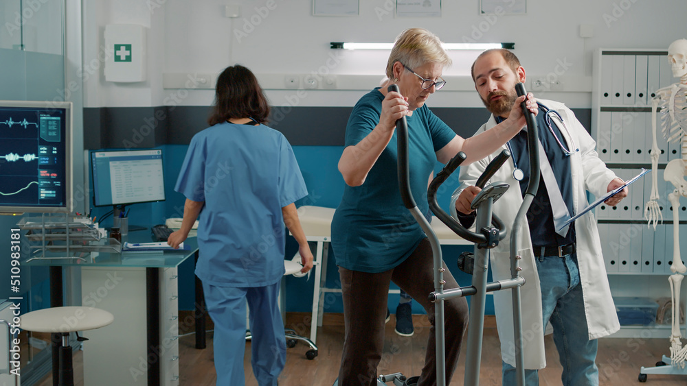 Senior patient doing muscle exercise on stationary bicycle to treat ...