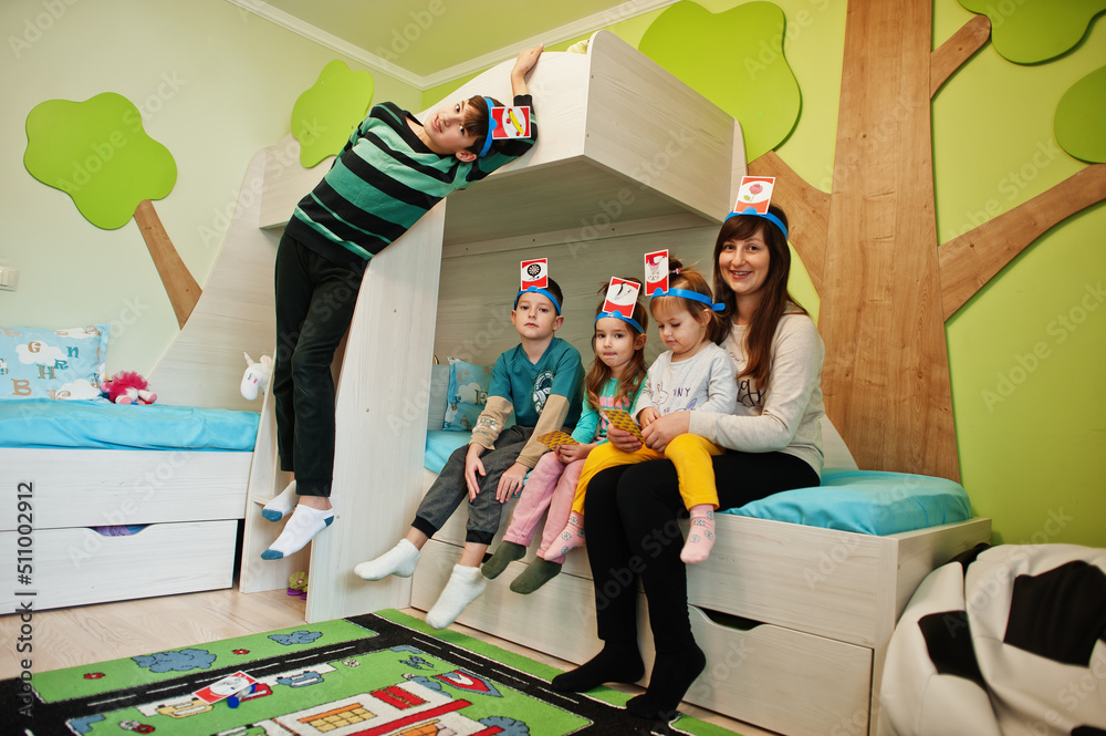 Happy family with four kids playing game guess who while having fun at ...