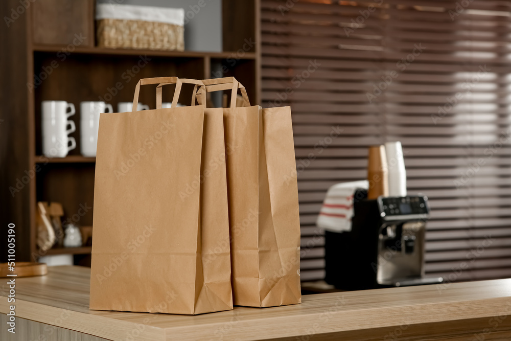 Paper bag on wooden counter in cafe, space for text Stock Photo | Adobe ...