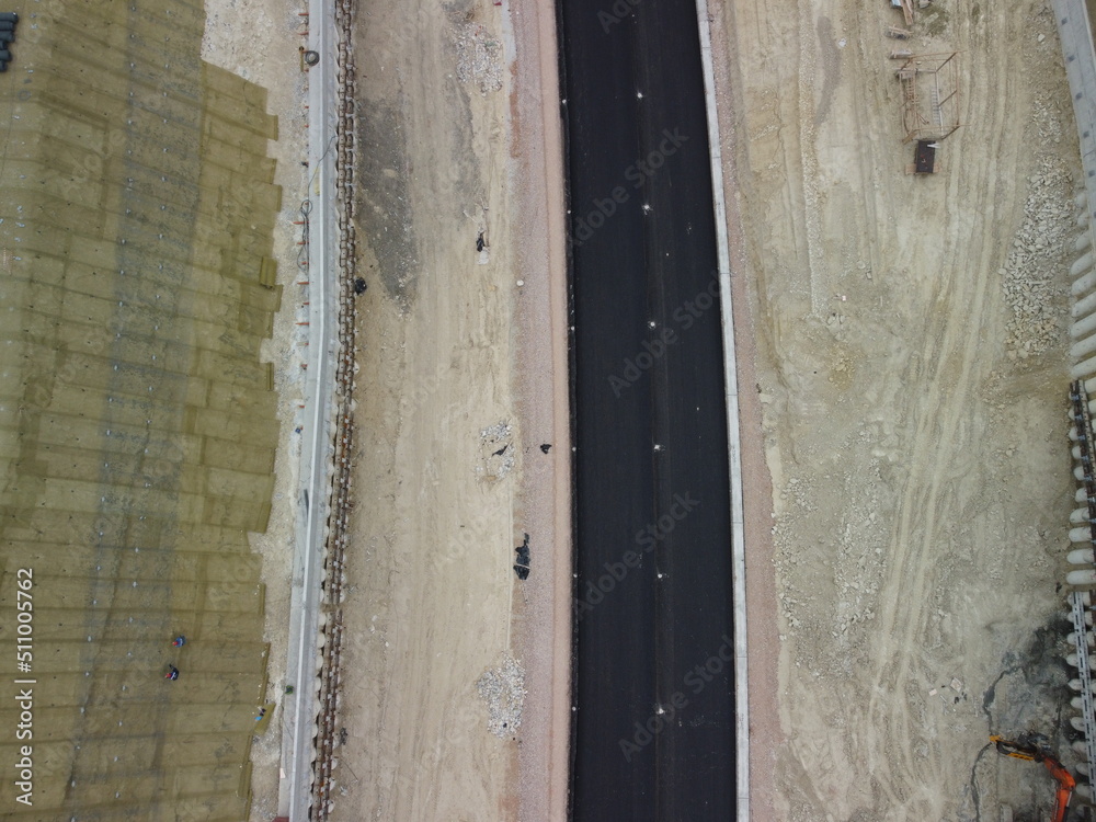 Workers reinforce the slope over the new road. Road construction in ...
