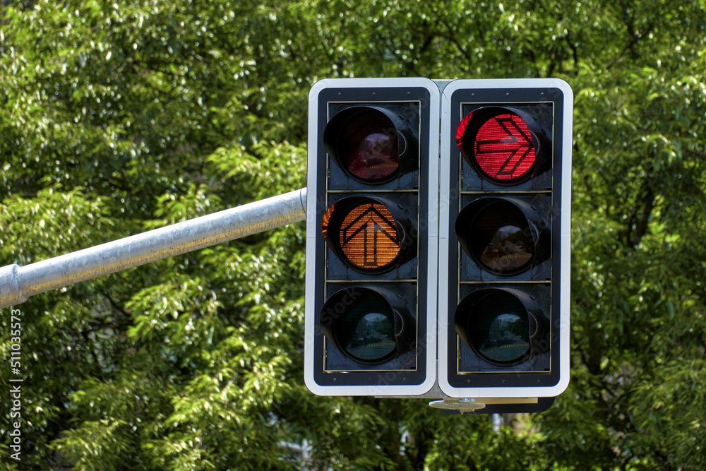 two traffic lights over urban intersection illuminated in one orange ...