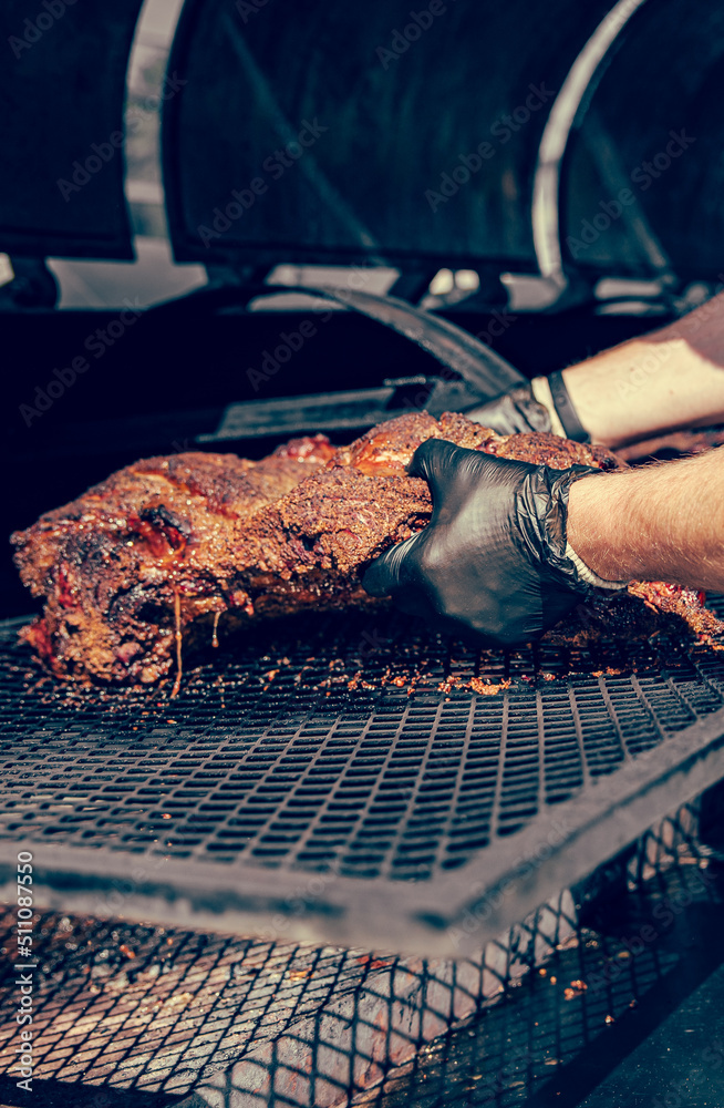 Chef pitmaster hand cooking grilled beef meat in BBQ smoker. Stock ...