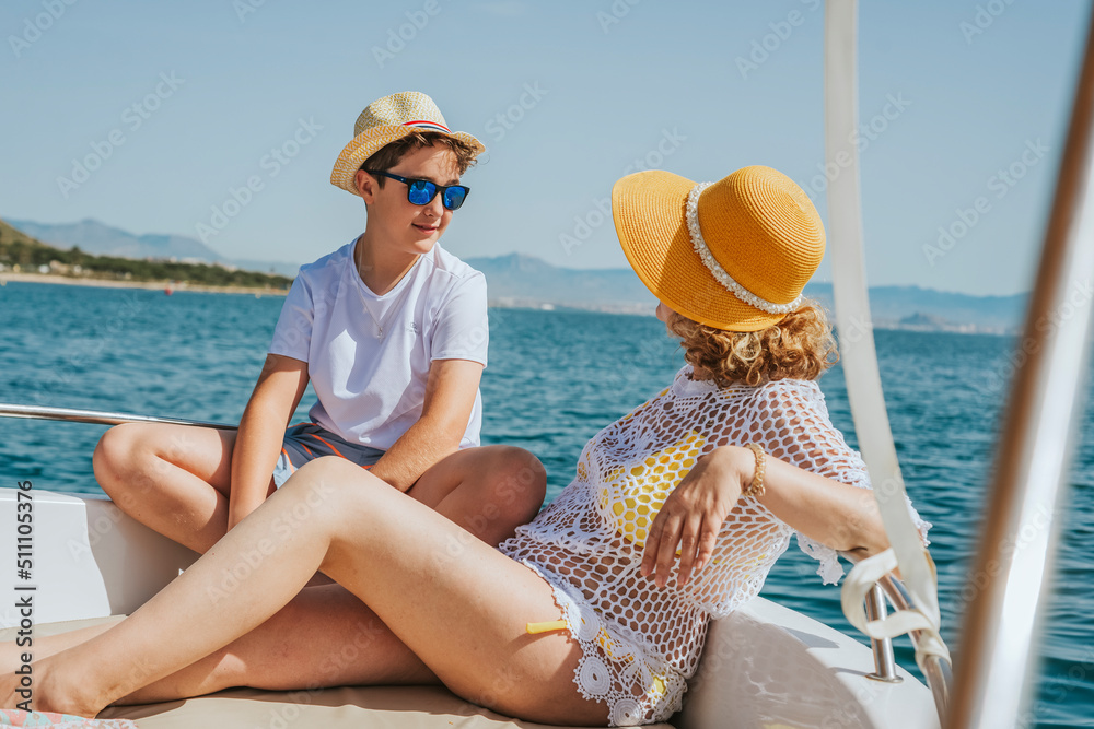 Child and his mother riding on the bow of the boat. Summer vacation ...