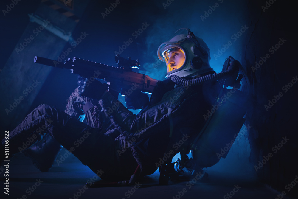 Spaceman or star trooper in the helmet and with rifle in the blue smoke ...