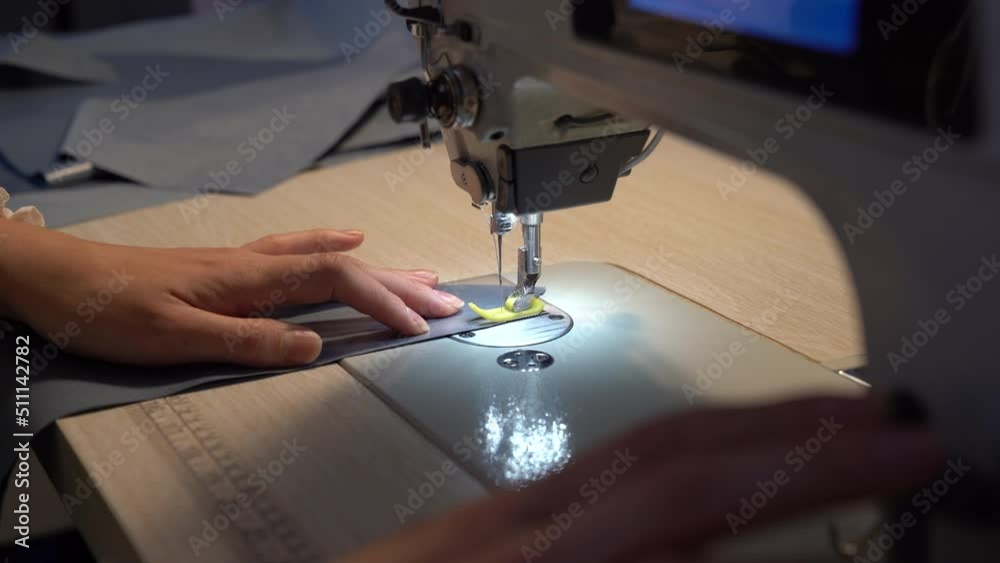 Woman tailor work on sewing machine stitching patterns of new ...