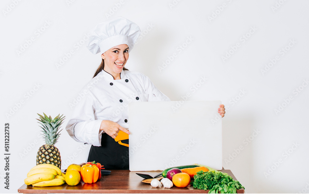Chef woman with vegetables at table holding blank menu. Girl chef in ...