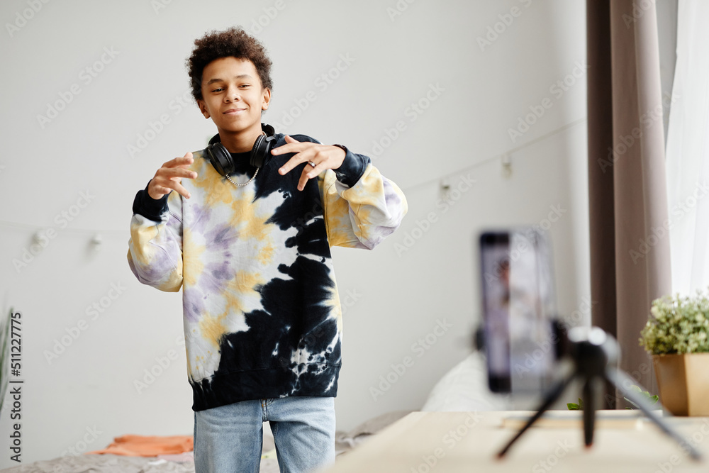 Portrait of smiling Gen Z teenager filming video for social media ...