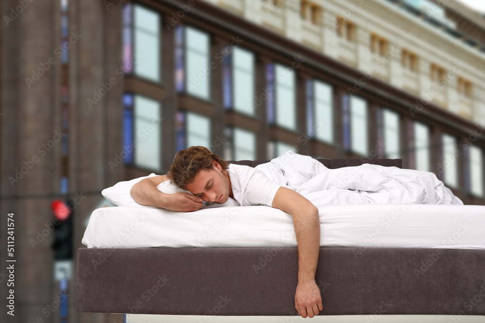 Man sleeping in bed and beautiful view of building on background. Good ...