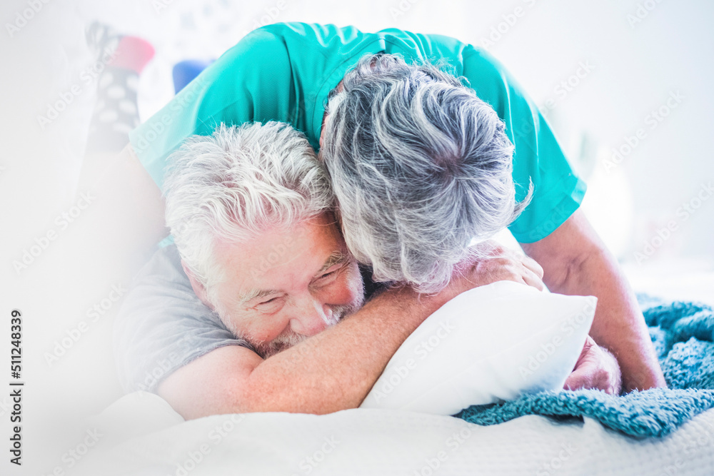 Mature couple having fun together in the bed under the cover laughing ...