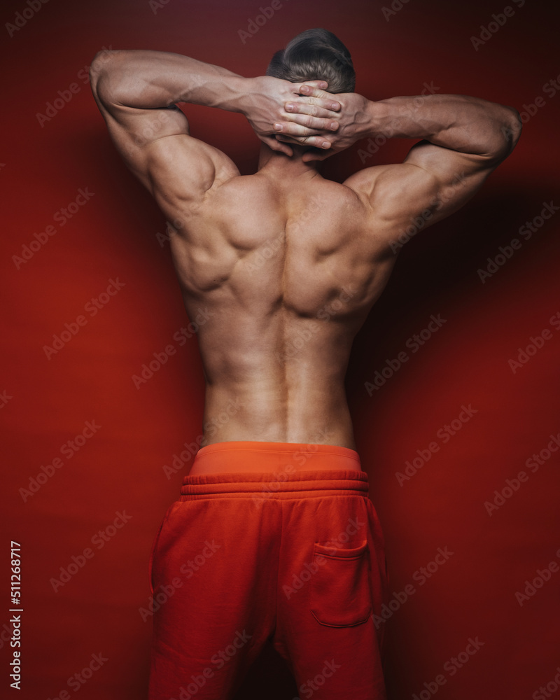 Muscular male back with hands behind head. Athletic young guy shows his ...