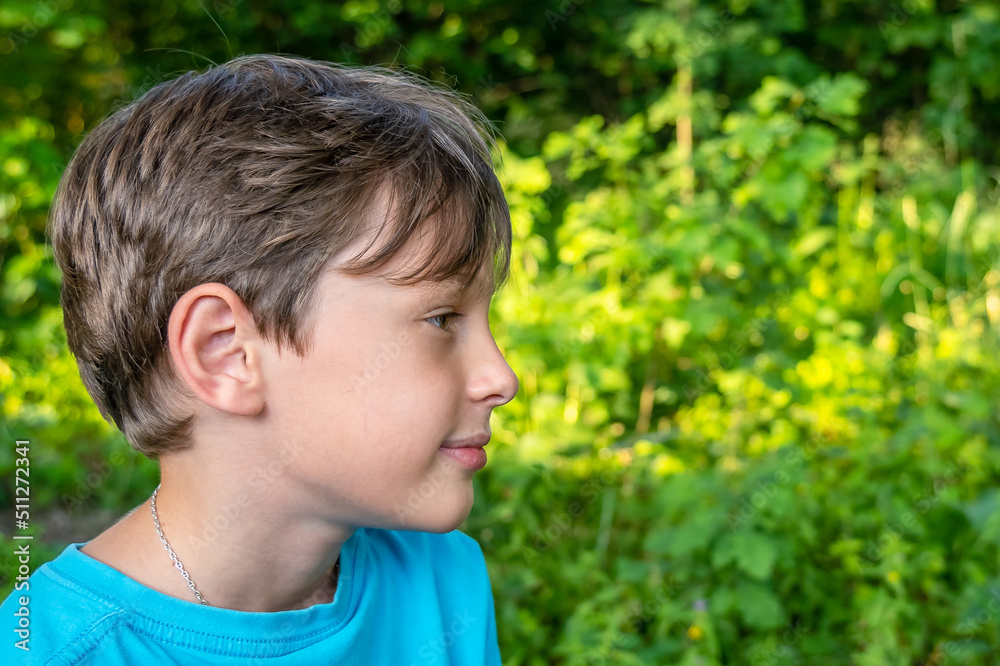 Smiling boy in the park side view. Portrait of a smiling 9-year-old boy ...
