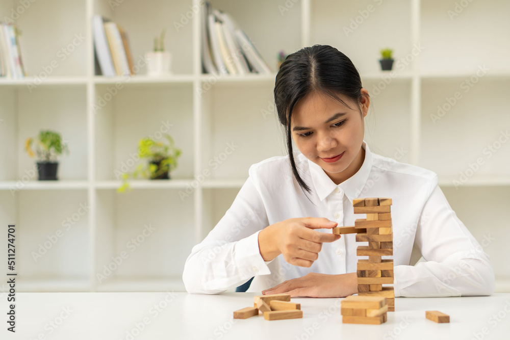 Asian business woman placing and pulling wooden blocks on wooden block ...