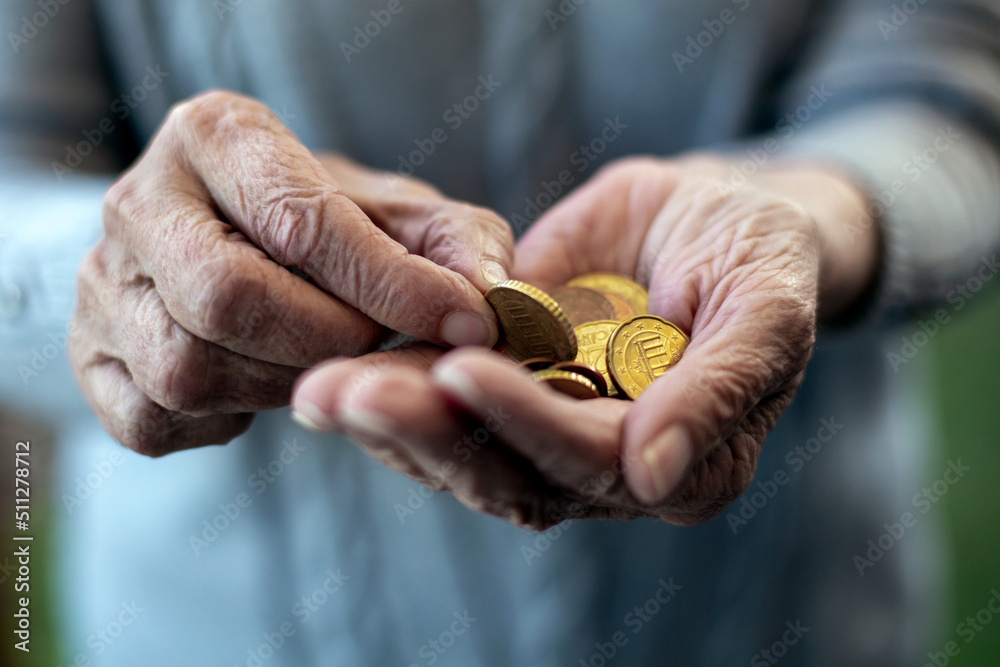 older womans hand holding coins and counting Stock Photo | Adobe Stock