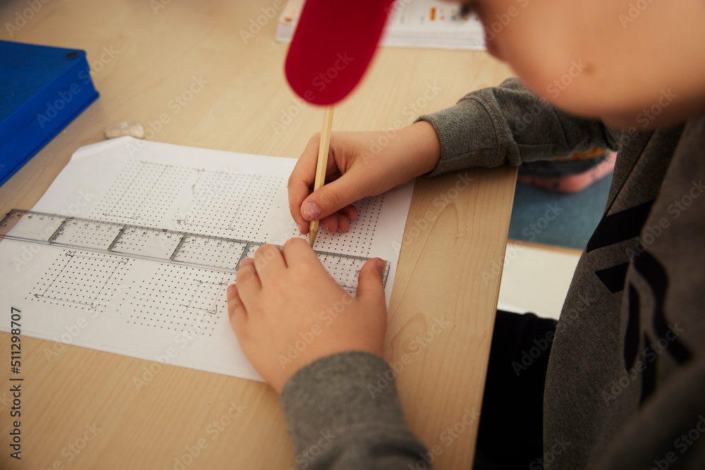 Boy using ruler and pencil at school Stock Photo | Adobe Stock