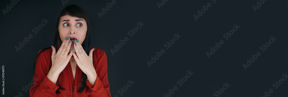 Close-up portrait of a terrified woman. A young brunette woman in red ...