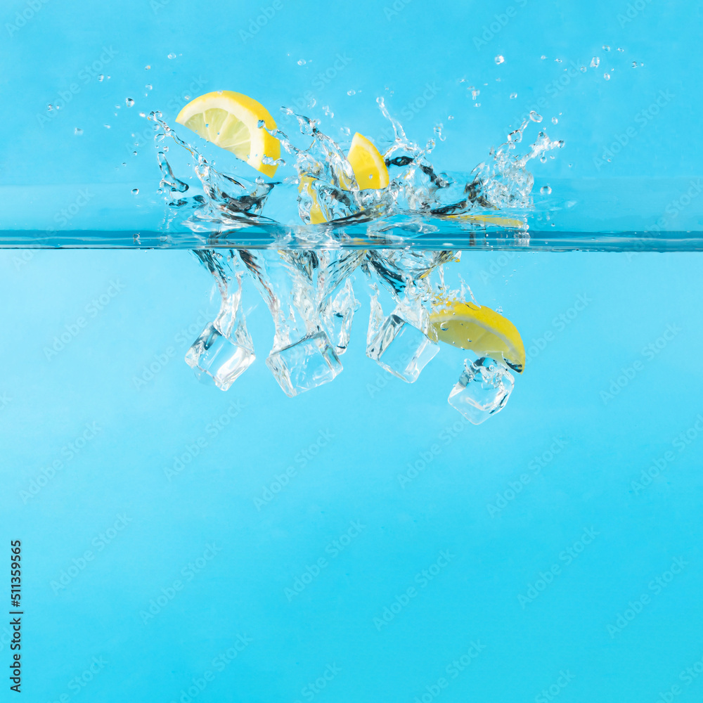 Water splash with fresh lemon fruit slices and ice cubes. Minimal ...