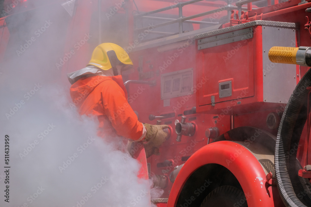 Firefighters drag fire hoses connected to fire truck hoses. in ...
