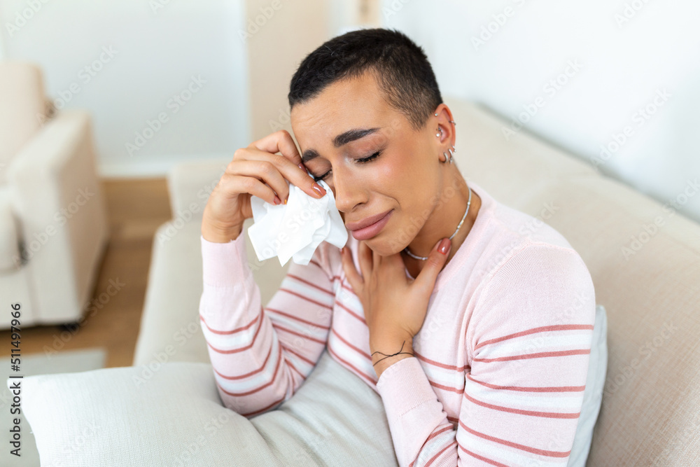 Young woman sitting in room feeling pain with life problem. Crying ...