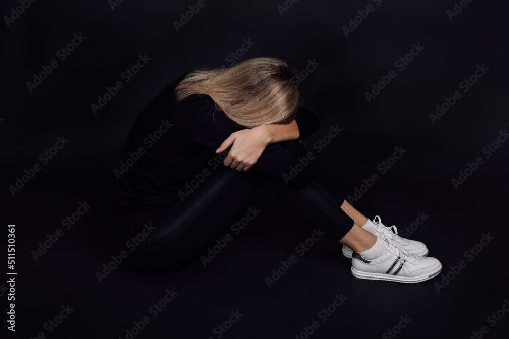 Reserved Caucasian blonde woman closed from world sitting on floor with ...