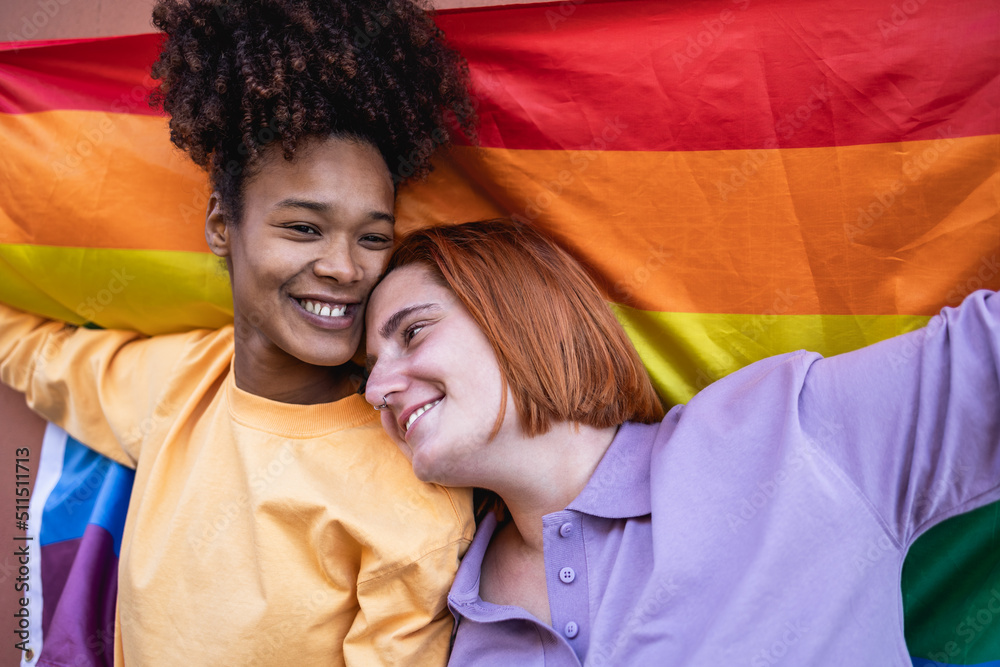 Happy gay couple celebrating pride holding rainbow flag outdoor - LGBTQ ...