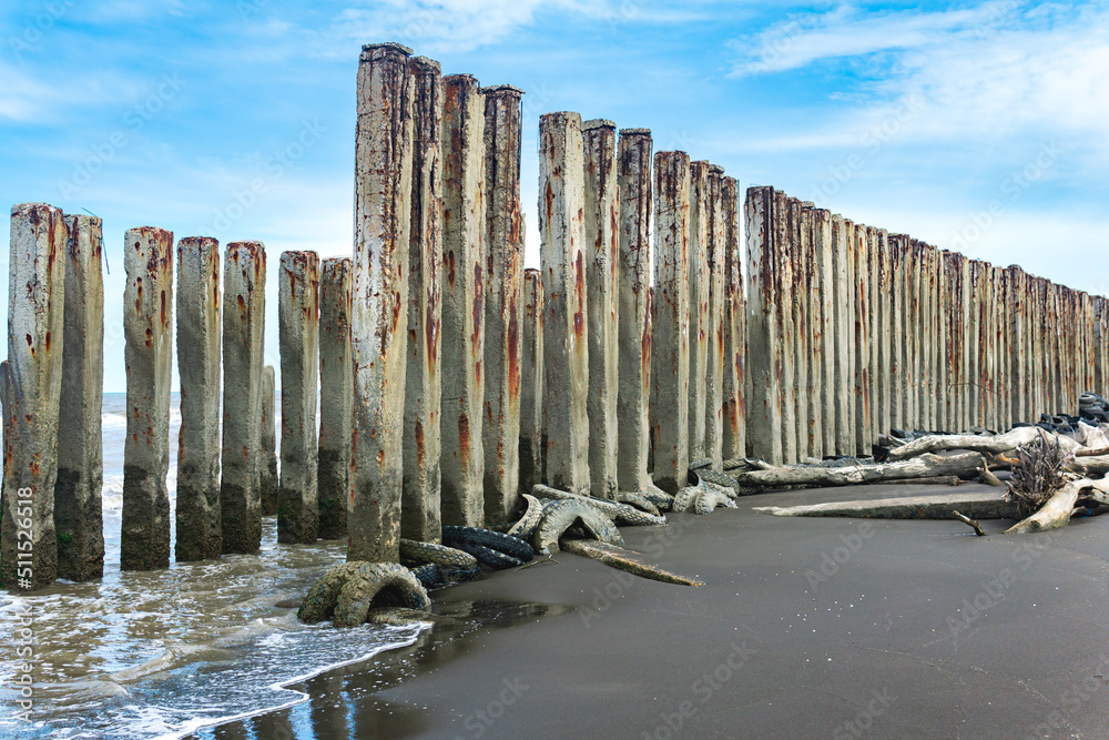 old groyne made of concrete piles preventing erosion of the sandy shore ...