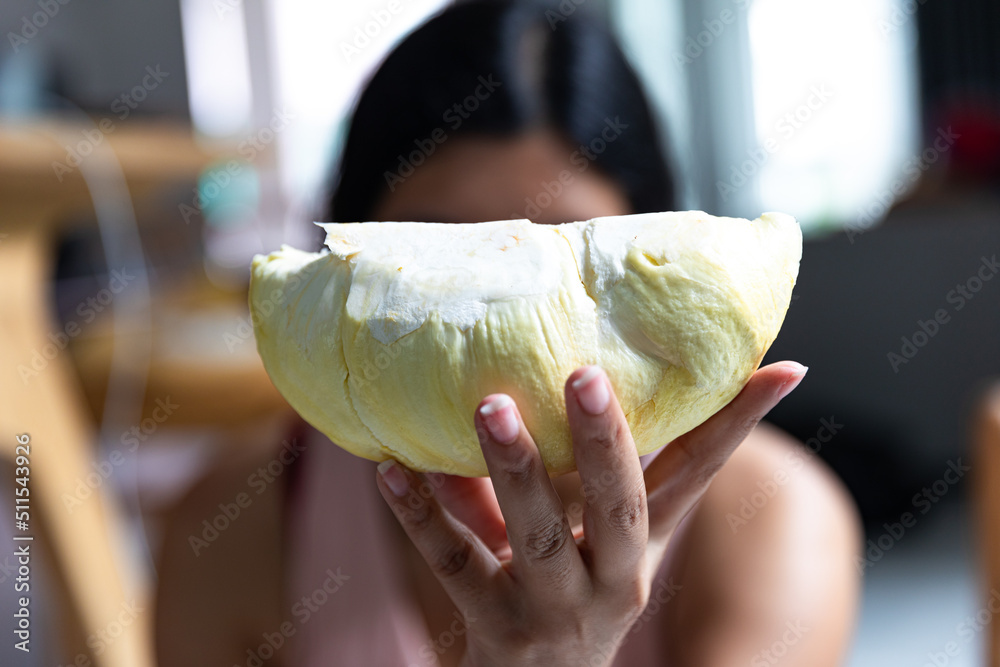 Close up A woman handle durian show the yellow durian meat to eat. The ...