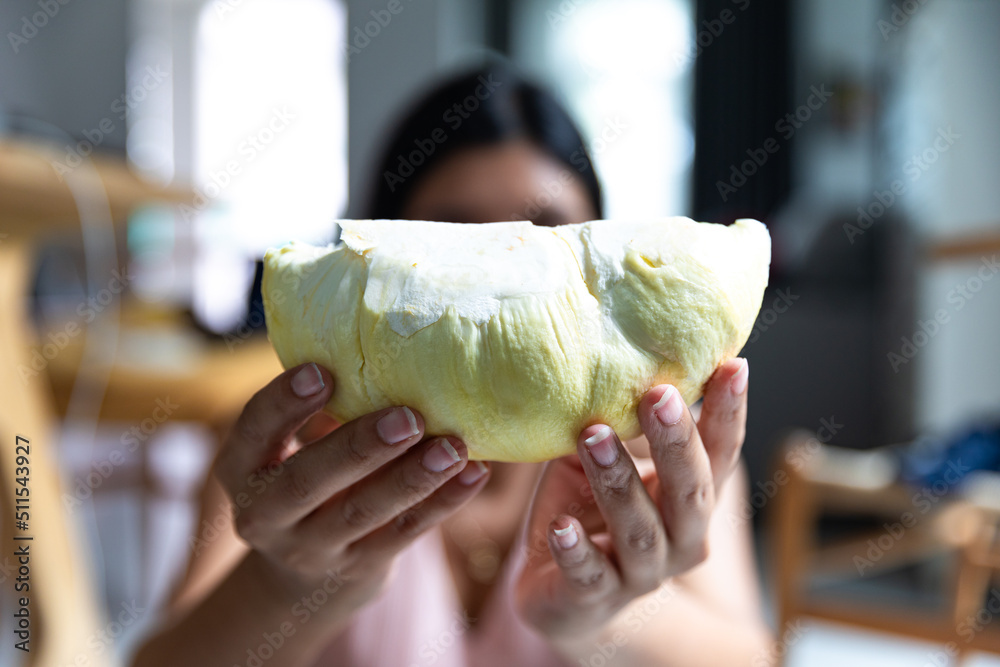 Close up A woman handle durian show the yellow durian meat to eat. The ...