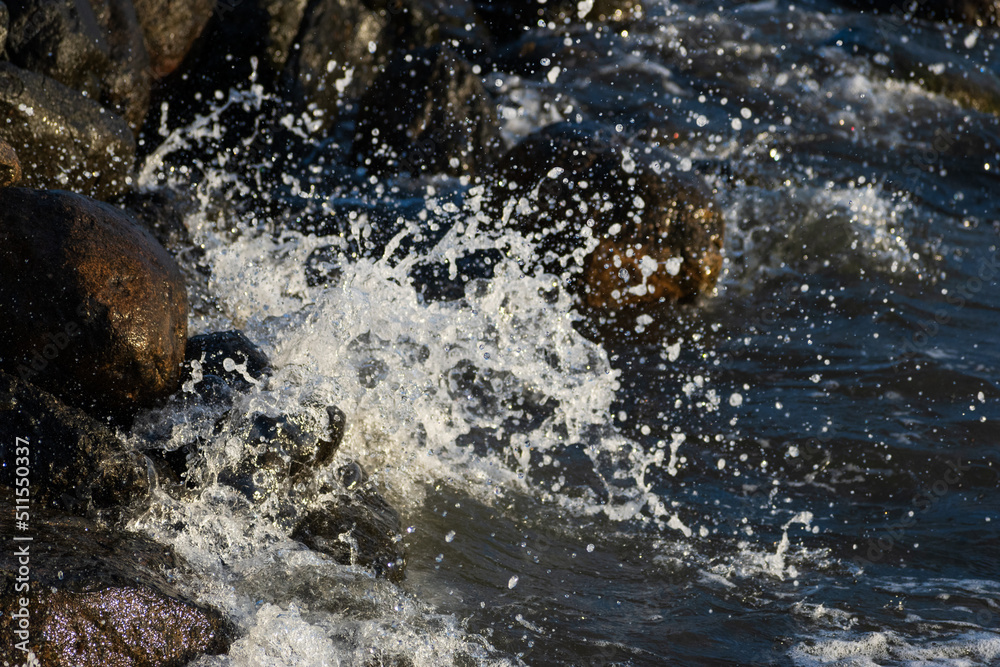 olas chocando contra las rocas de un rompe olas en las costas marinas ...